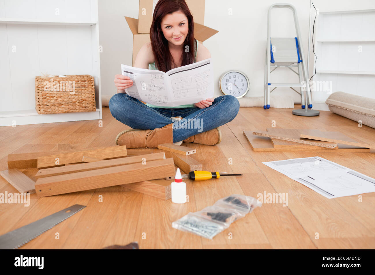 Cute red-haired female reading a manual before do-it-yourself Stock ...