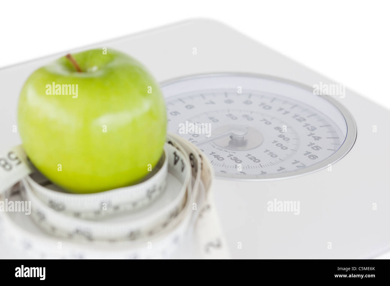 Green apple circled with a tape measure and weigh-scale Stock Photo - Alamy