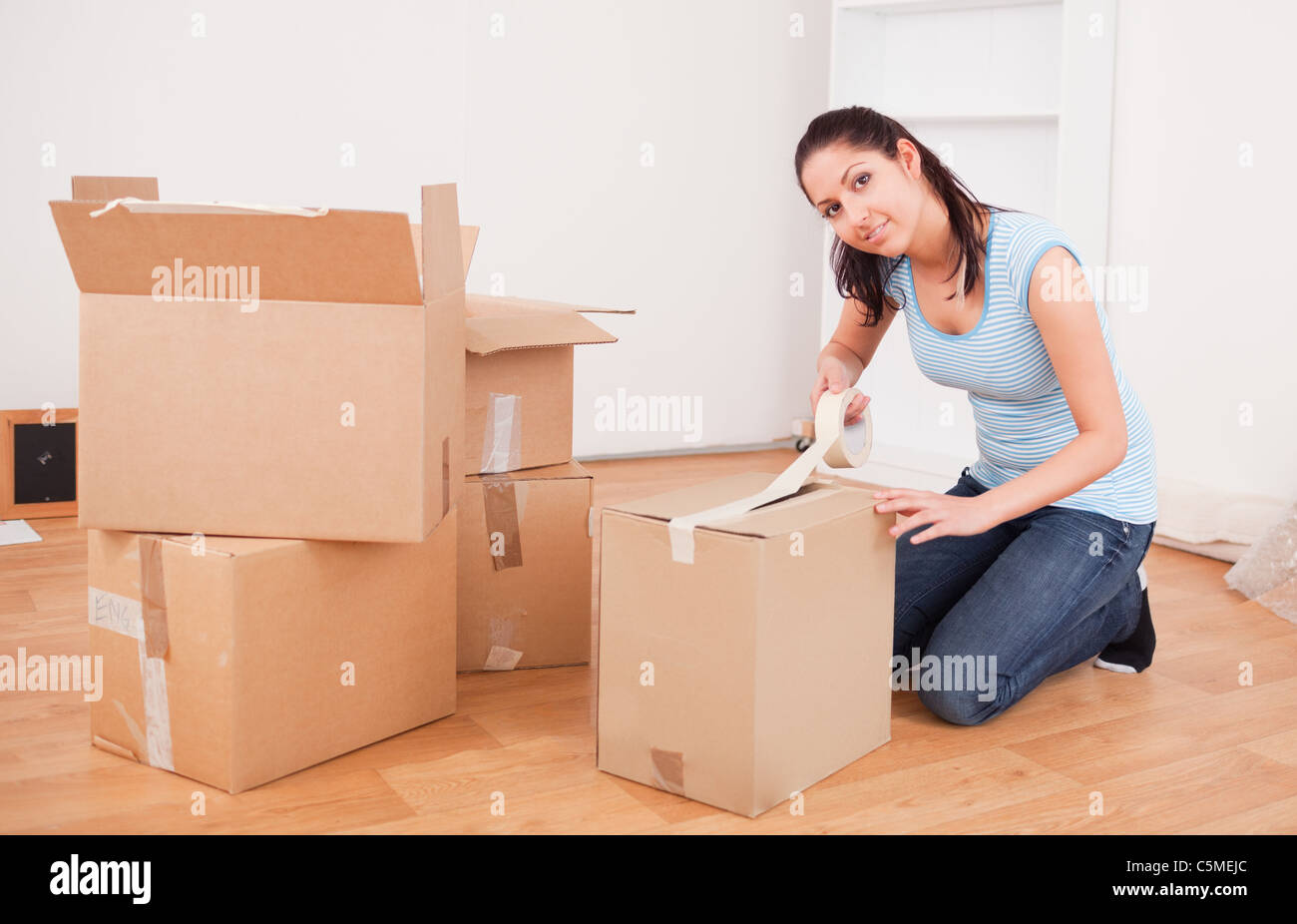 Young brunette taping a box Stock Photo - Alamy