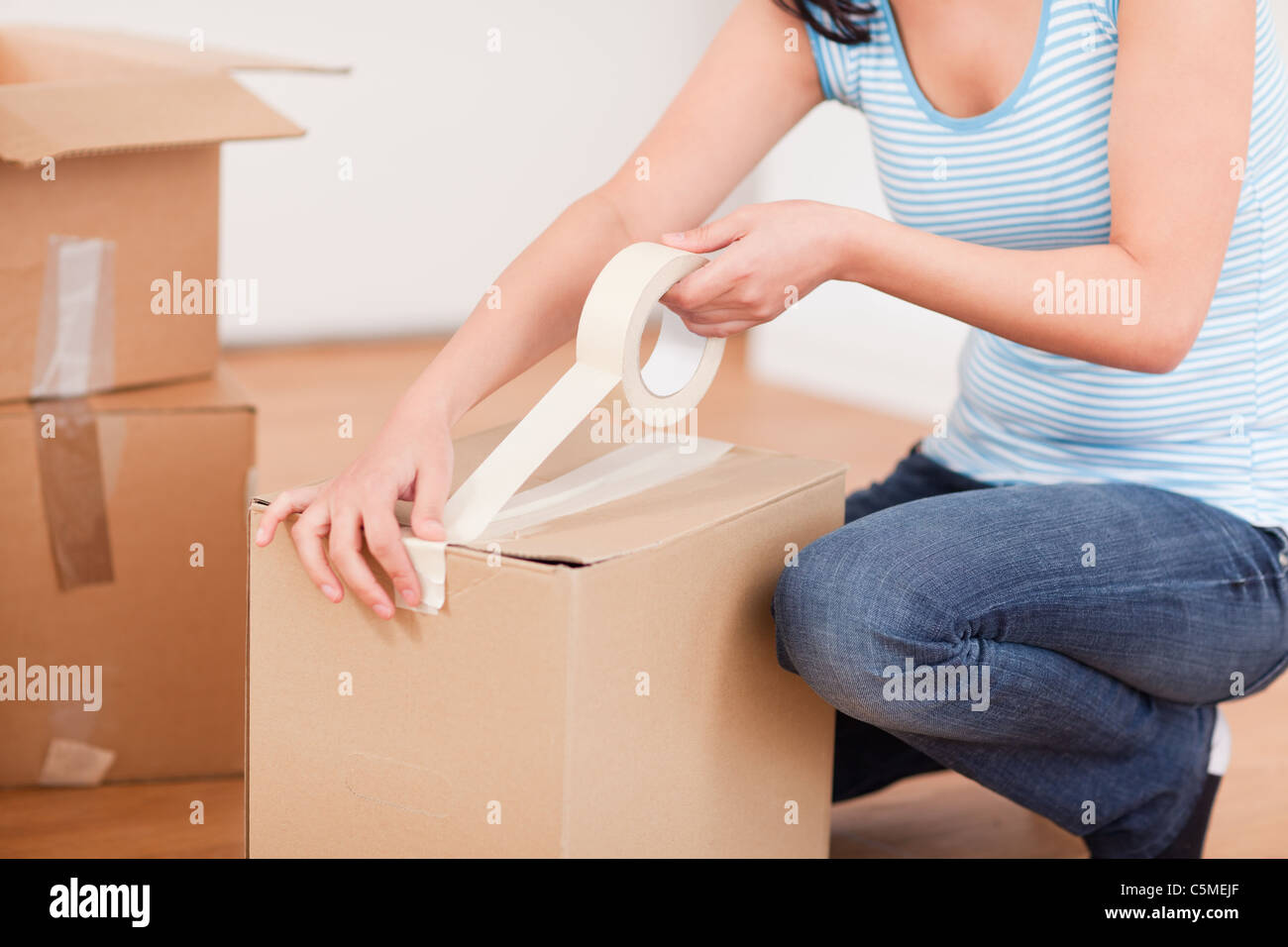 Feminine hands taping a box Stock Photo - Alamy