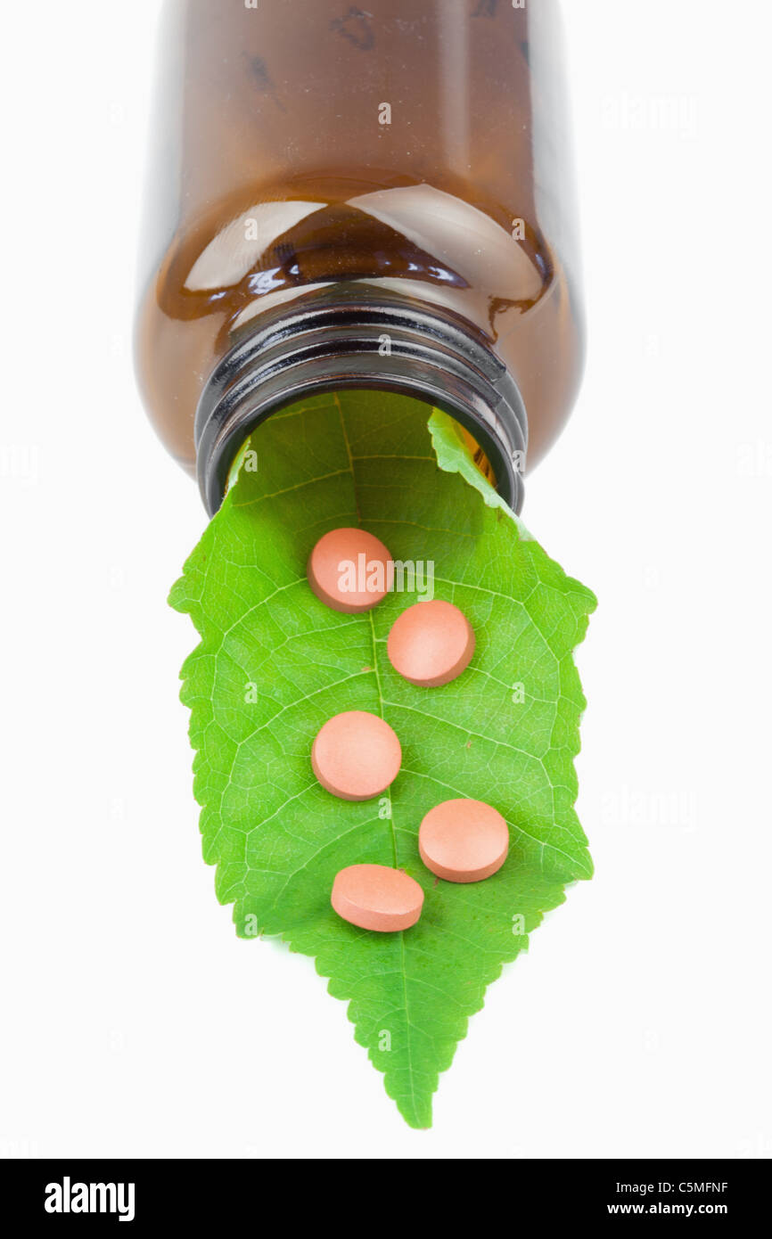 Leaf and pills in a small bottle Stock Photo - Alamy