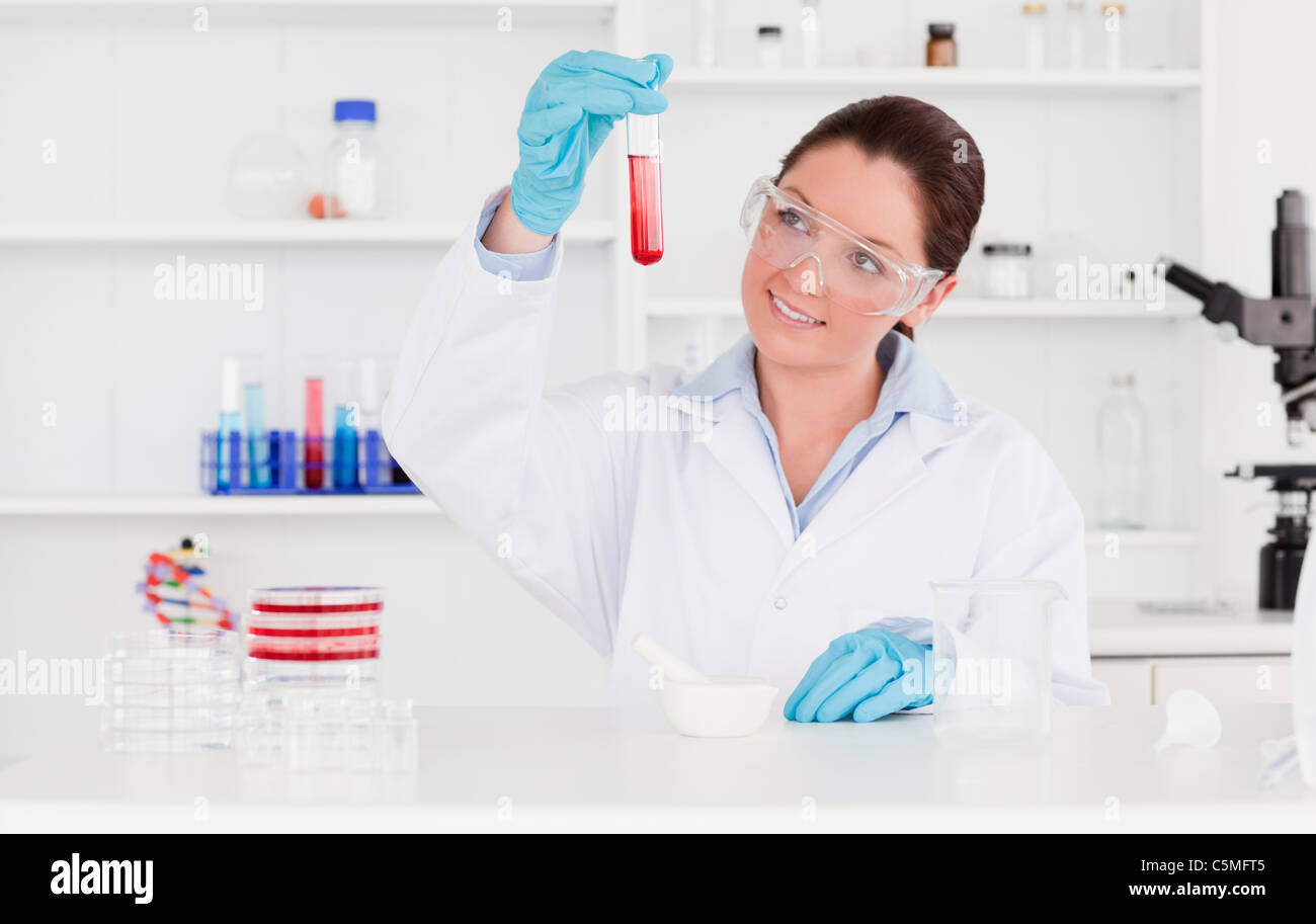 Young scientist looking at a test tube Stock Photo - Alamy