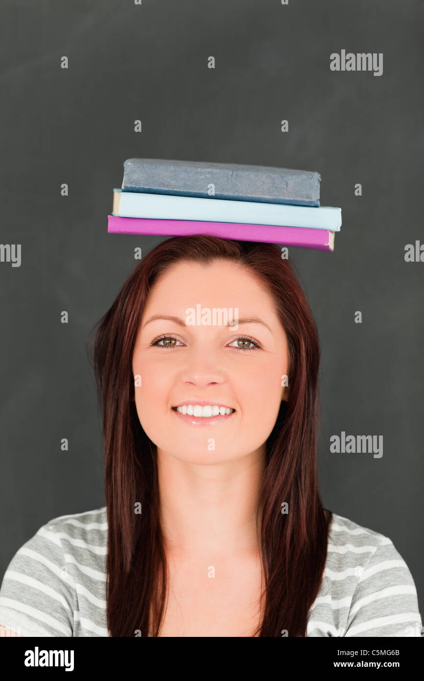 Portrait of a smilling young woman wearing books on her head Stock ...