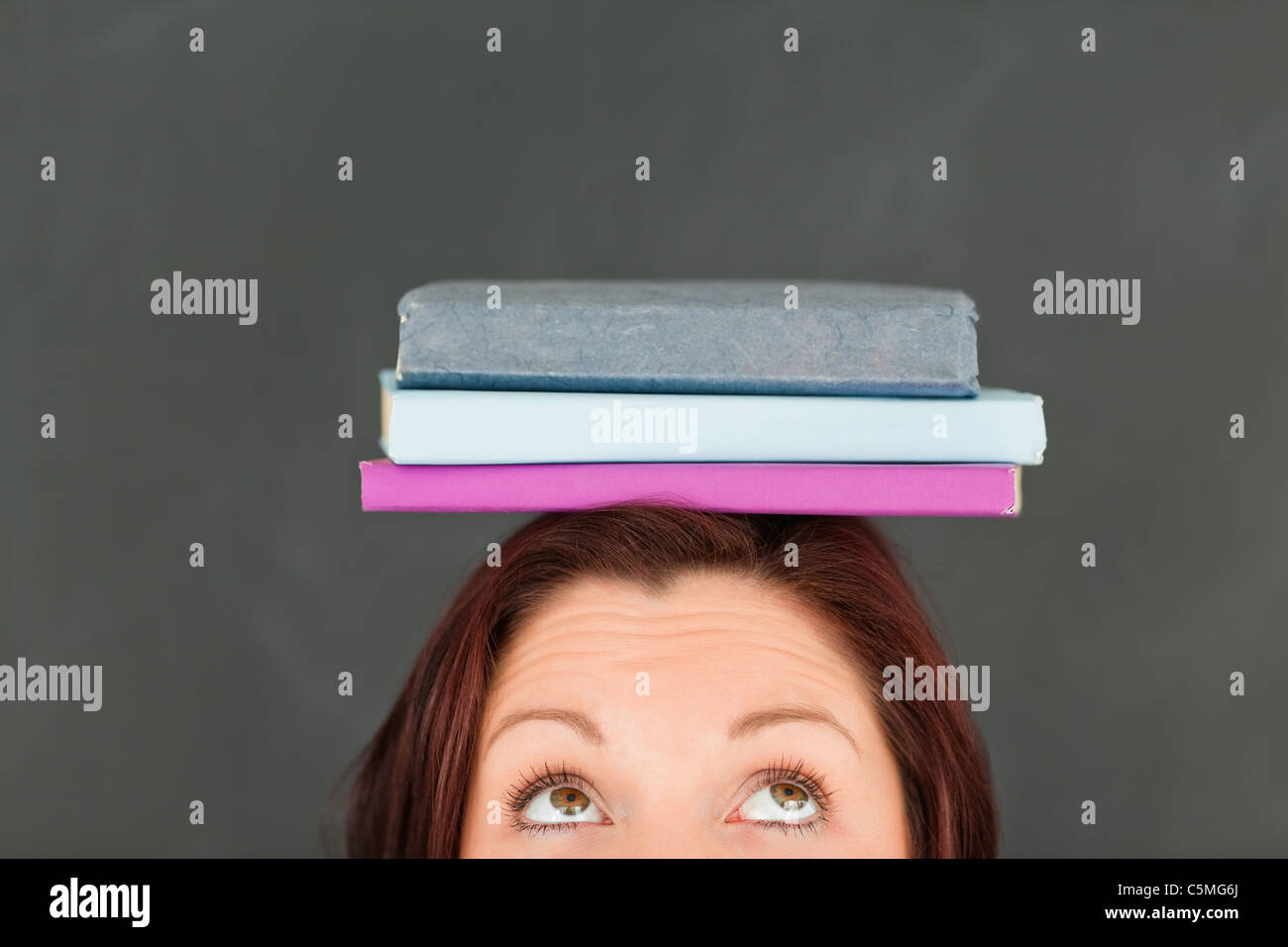 Young caucasian wearing books on her head Stock Photo - Alamy