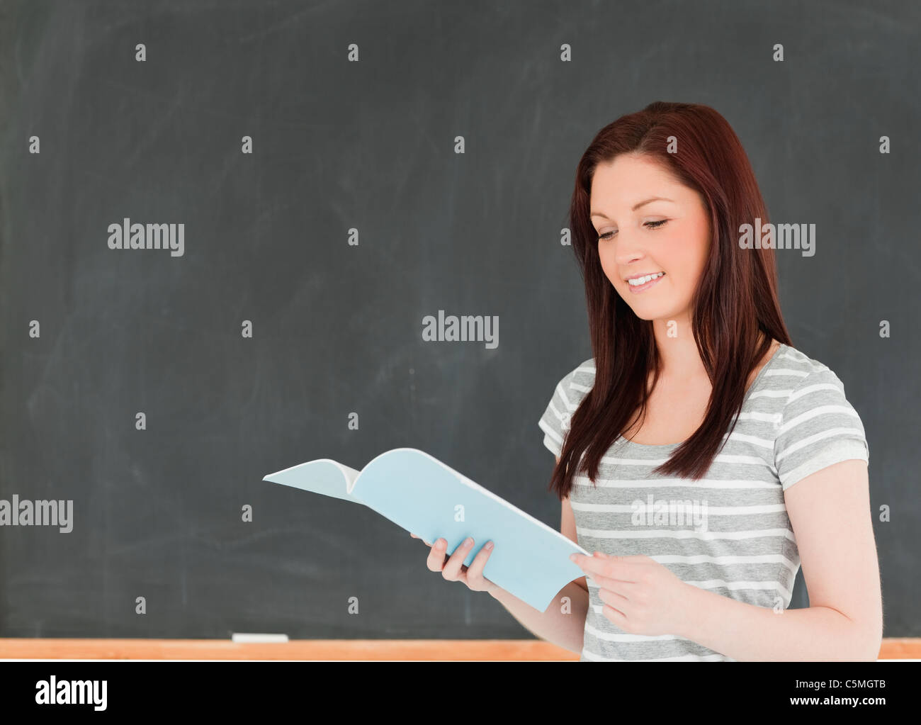 Smiling woman reading her notes Stock Photo - Alamy