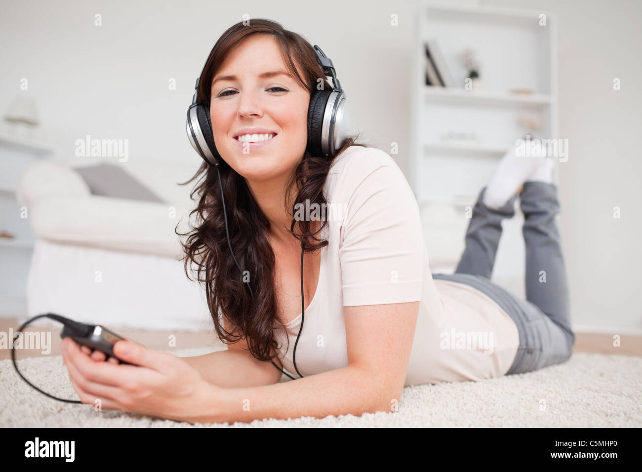 Good looking brunette woman listening to music with her mp3 player ...