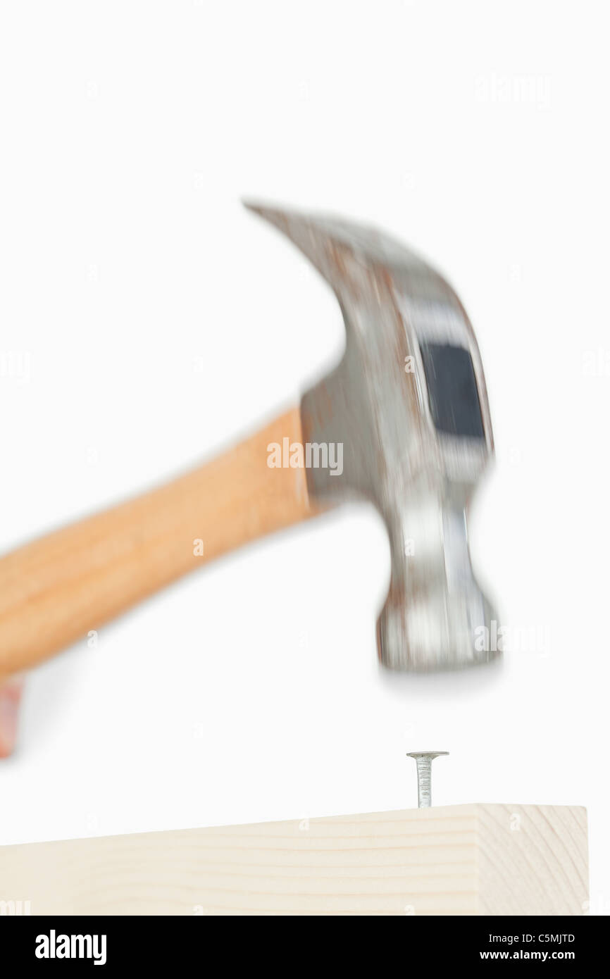 Close up of a hammer driving a nail into a board Stock Photo - Alamy