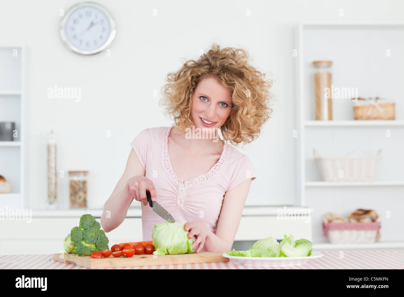 Pretty blonde woman cooking some vegetables in the kitchen Stock Photo ...