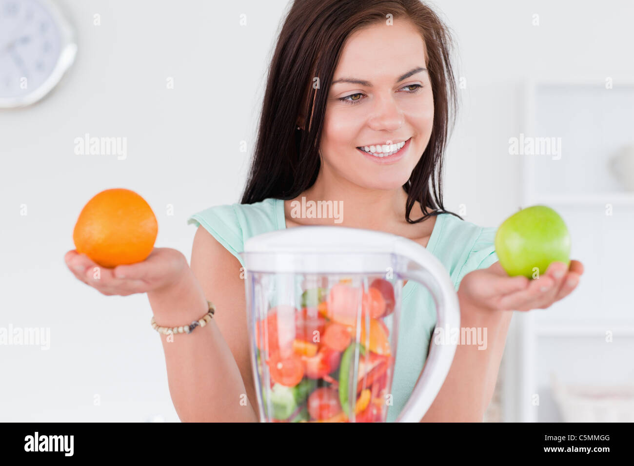 Charming woman with a blender and fruits Stock Photo - Alamy