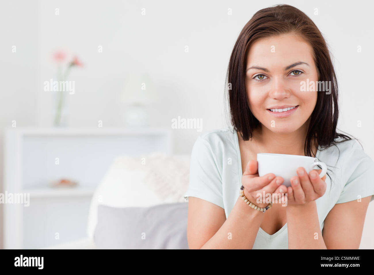 Beautiful dark-haired woman drinking tea Stock Photo - Alamy