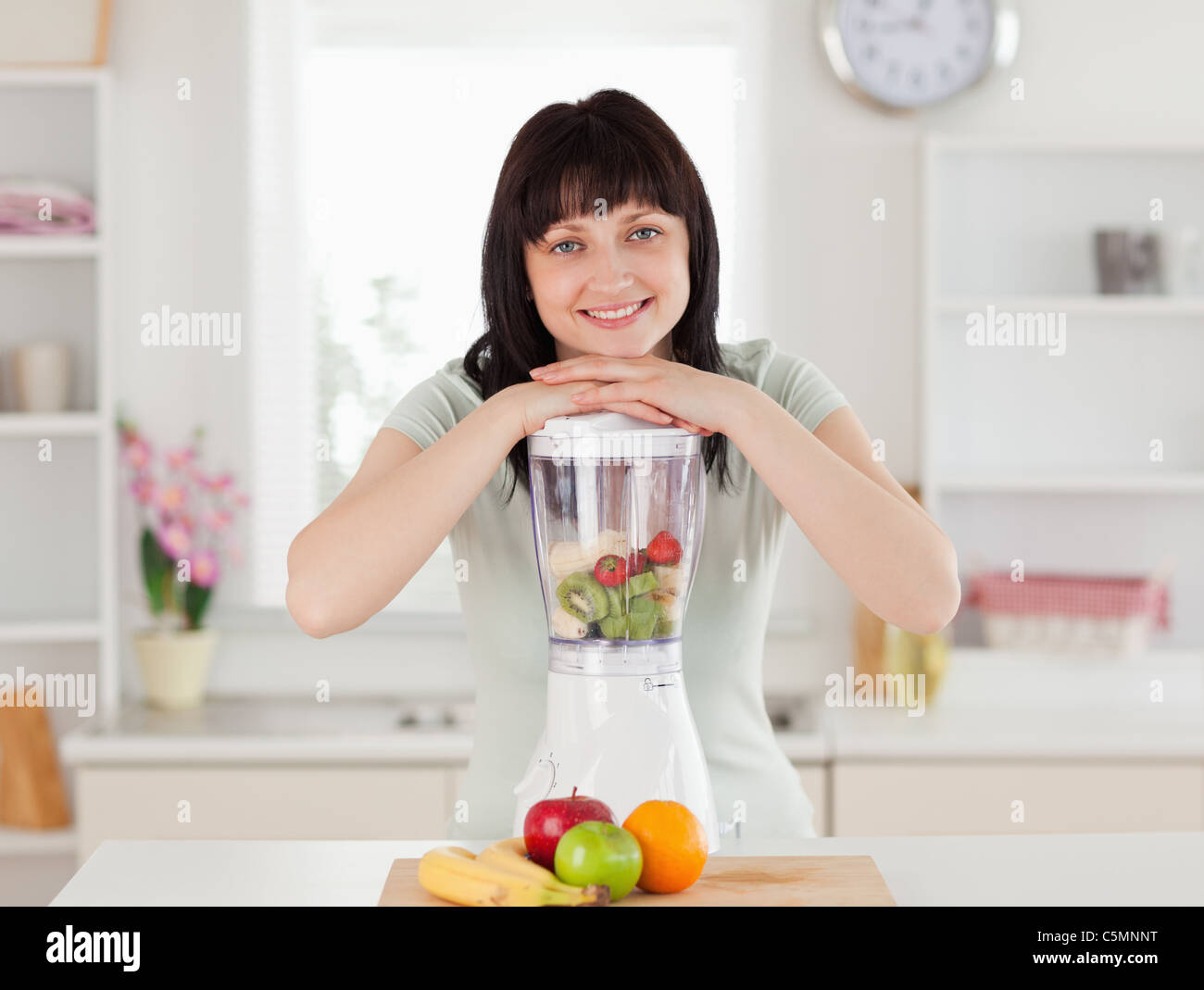 Good looking brunette woman posing with a mixer while standing Stock ... Good looking brunette woman posing with a mixer while standing Stock ...