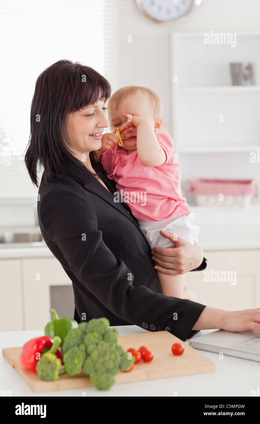 Good looking brunette woman in suit holding her baby in her arms Stock ...