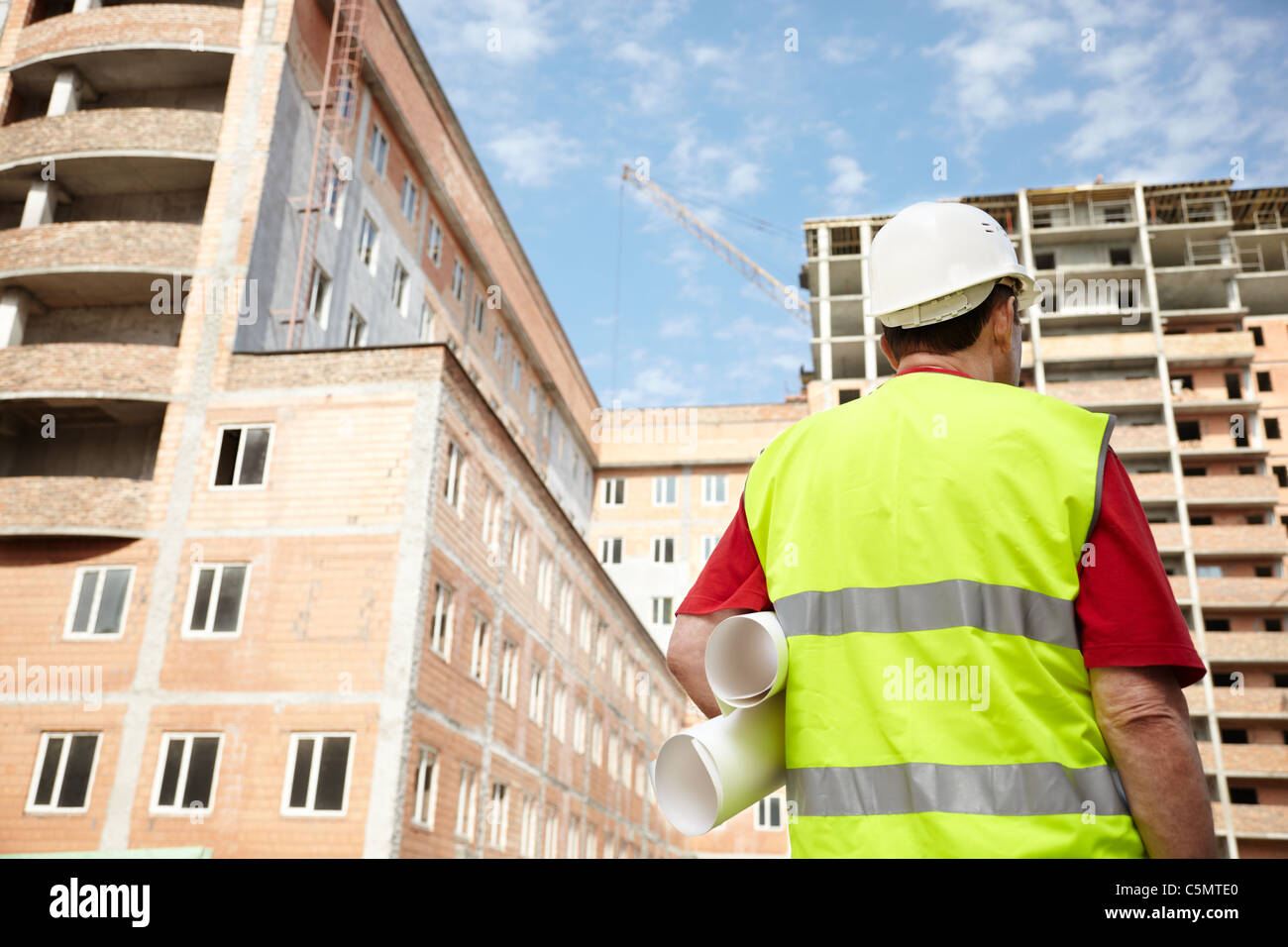 real builder with blueprints on construction site Stock Photo - Alamy