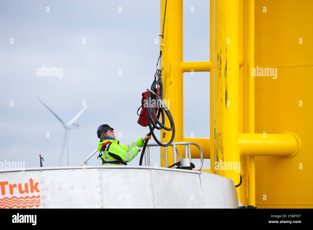 Offshore workers working on a wind turbine at the Walney Offshore ...
