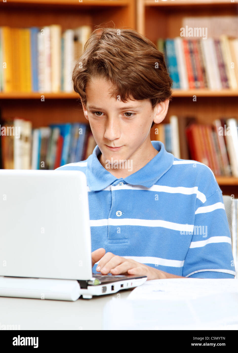 Cute little boy using a netbook computer in the school library Stock ...