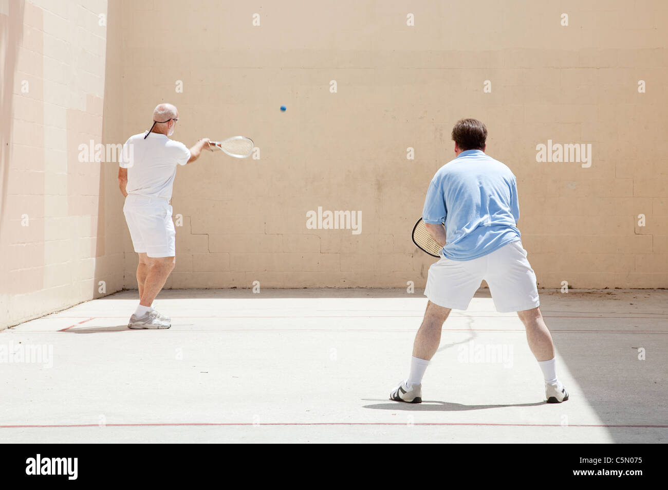 Two men, could be father and son, playing racquetball together Stock ...