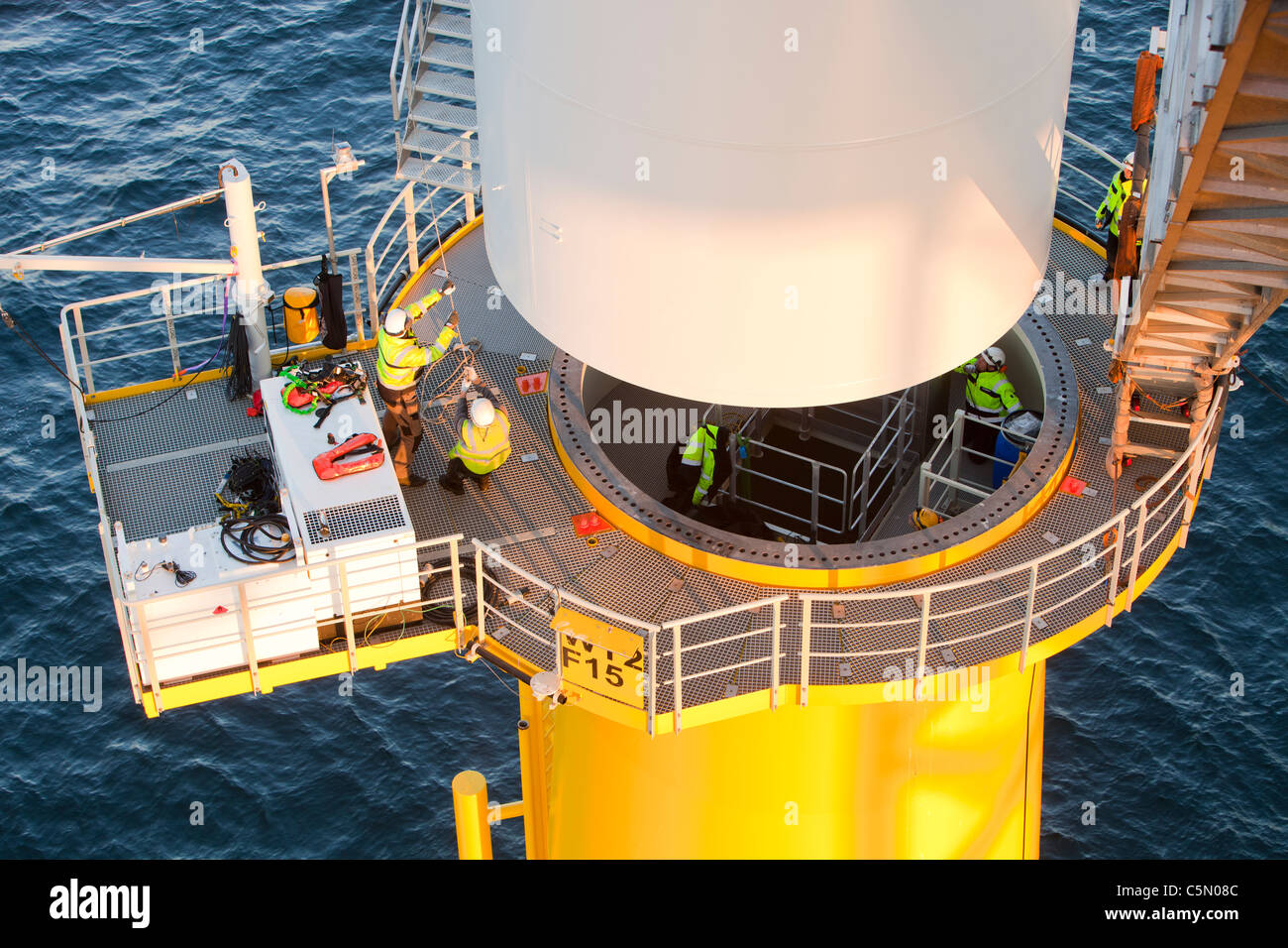 A tower piece being lowered onto a wind turbine base on the Walney ...