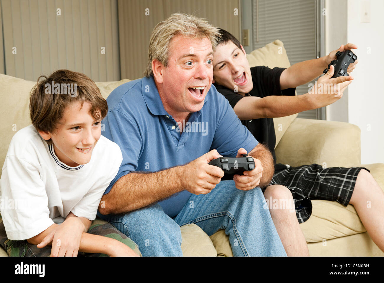 Uncle and his two nephews playing video games together. Could also be ...