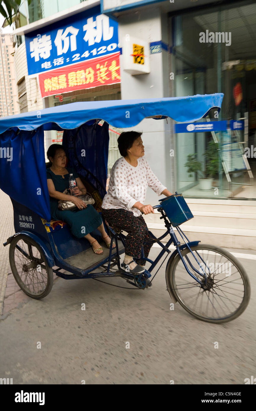 Trishaw / tri-shaw / cycle rickshaw and cyclist / driver with woman ...