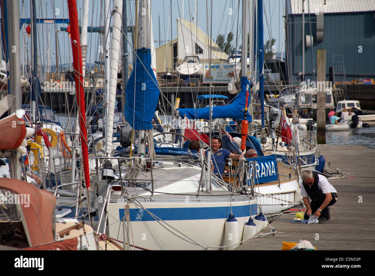 Harbour master collecting berthing dues, kneeling down on the pontoon ...