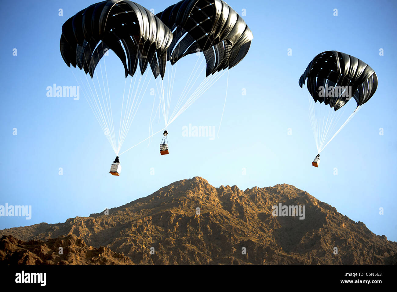 A U.S. Air Force Globemaster III airdrops supplies on Forward Operating ...