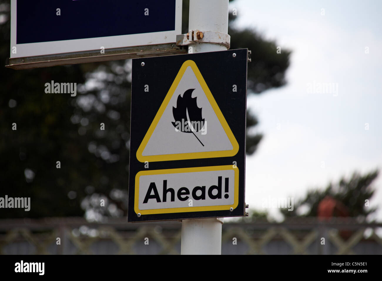Leaves on the track ahead sign at railway train station in UK Stock ...
