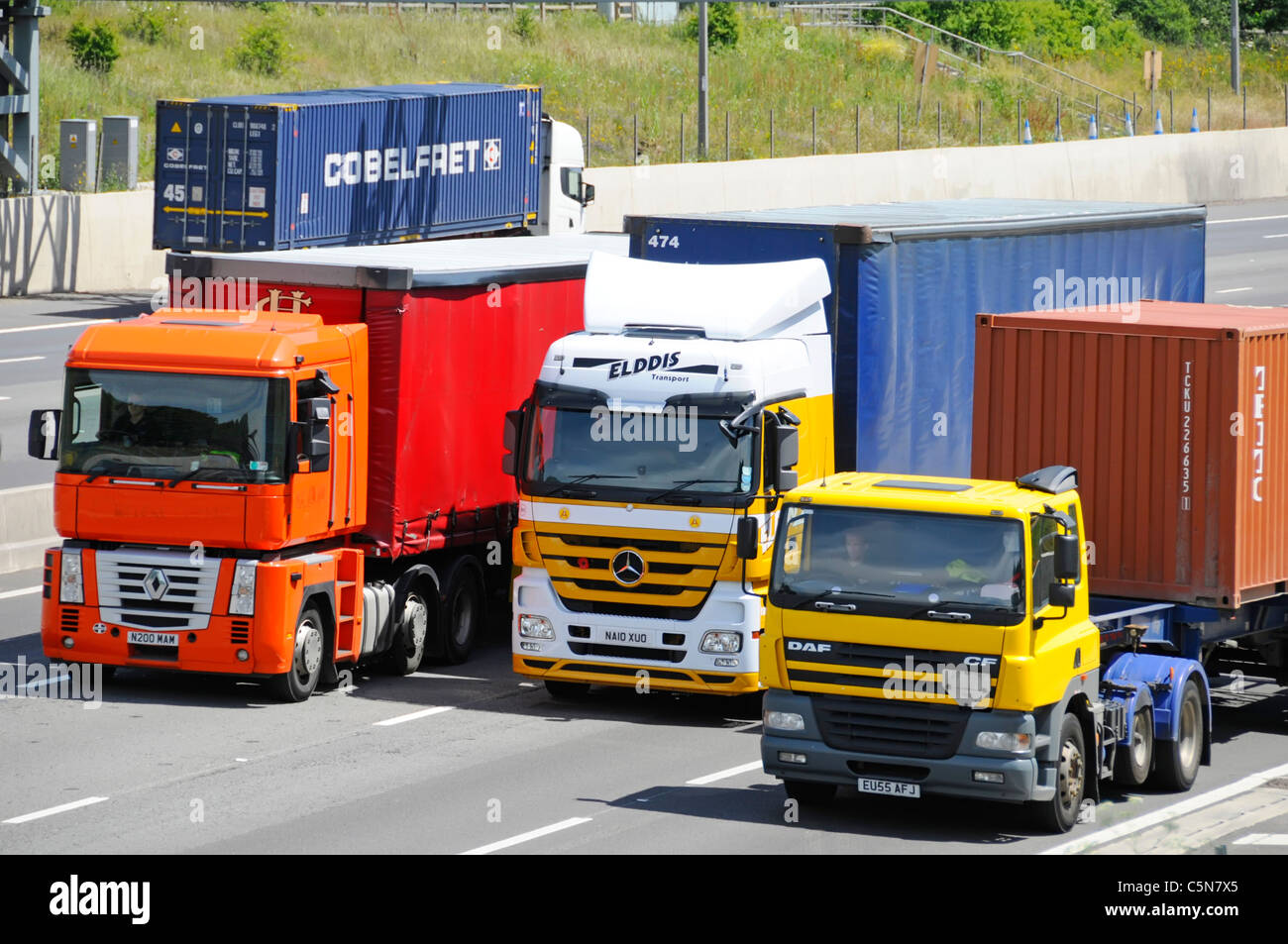 Three lorries in overtaking manoeuvre on four lane UK motorway Stock ...