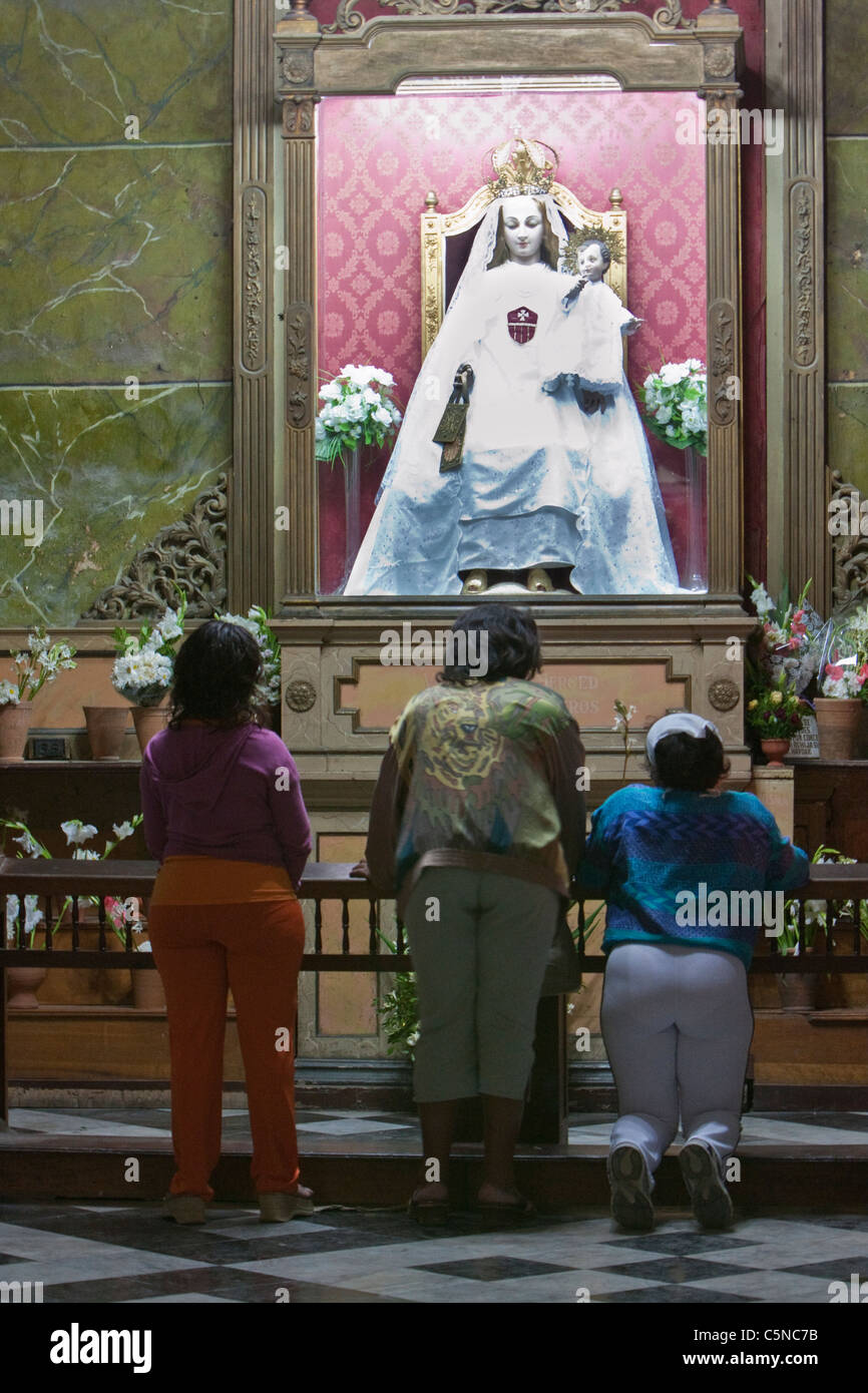 Cuba, Havana. Worshippers Praying before a Shrine to Jesus and the ...