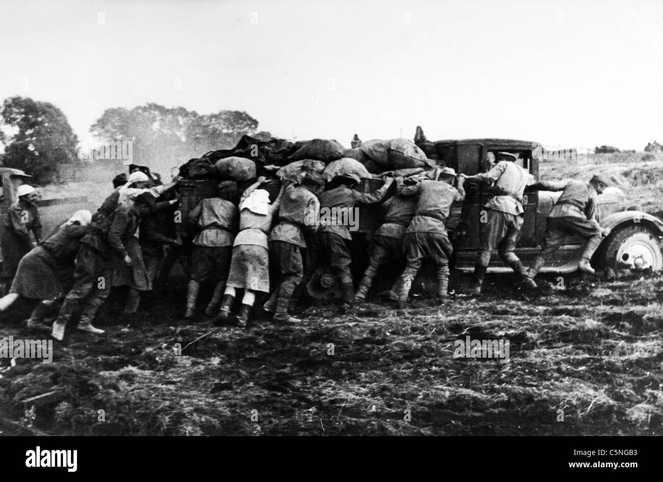 farmers help soldiers pushing a truck loaded in the Russian steppe ...