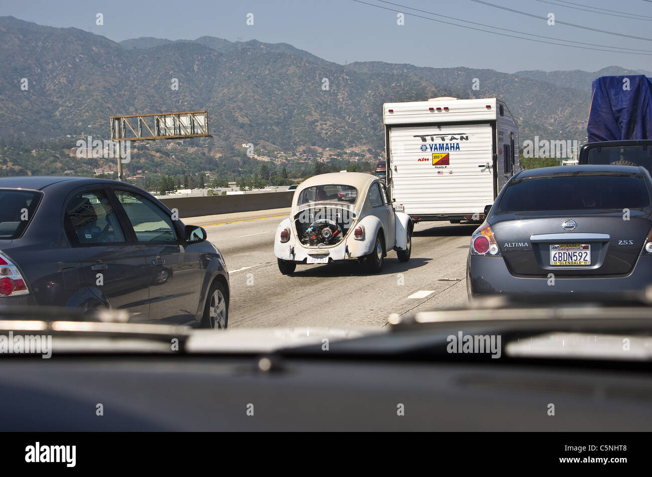 Los Angeles traffic, heat, highway of a small car moving without hood ...