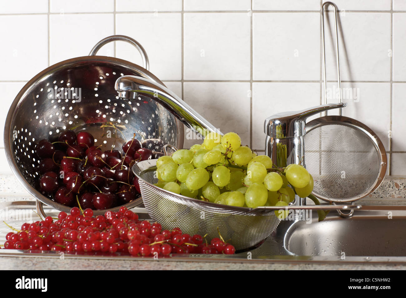Fresh fruits and berries being washed in a strainer Stock Photo - Alamy