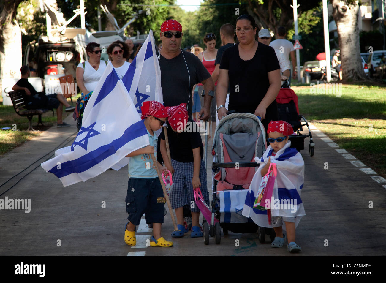 Parents pushing their children in strollers with the Israeli flags ...