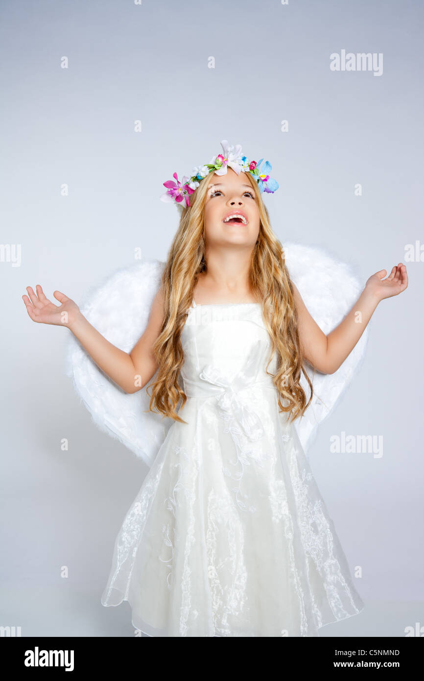 Children angel girl looking up sky with open hands and white wings ...