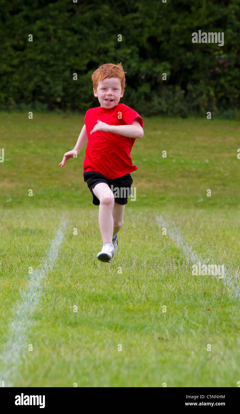 A boy running a race on school sports day in an English School Stock ...