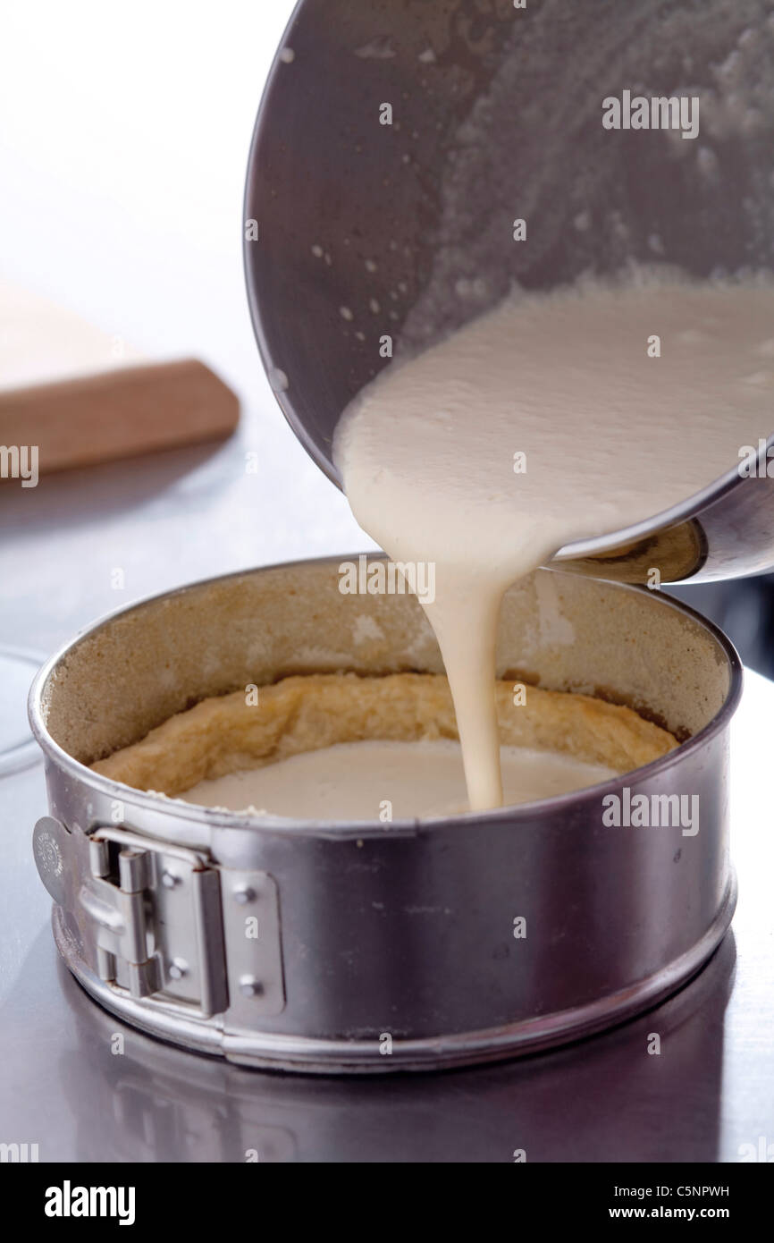 Pouring vanilla cream into shortcrust pastry case Stock Photo - Alamy