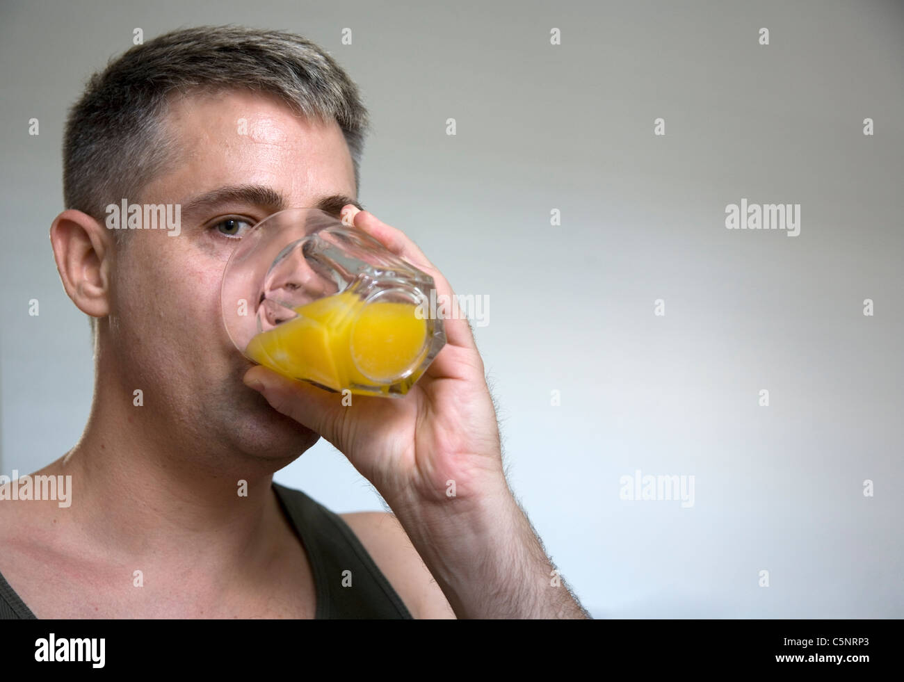 Man drinking orange juice Stock Photo - Alamy