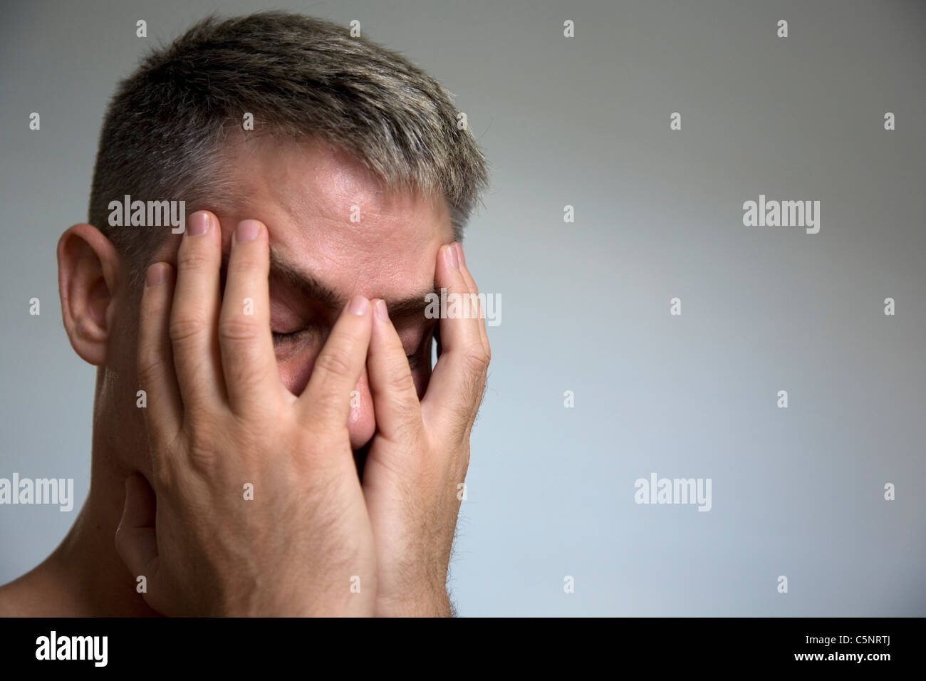 Man with hands on face Stock Photo - Alamy