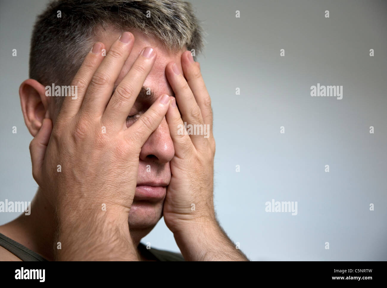Man with hands on face Stock Photo - Alamy