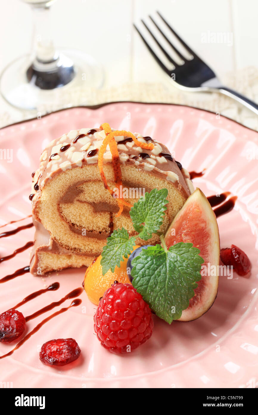 Slice of chocolate Swiss roll and fresh fruit Stock Photo - Alamy