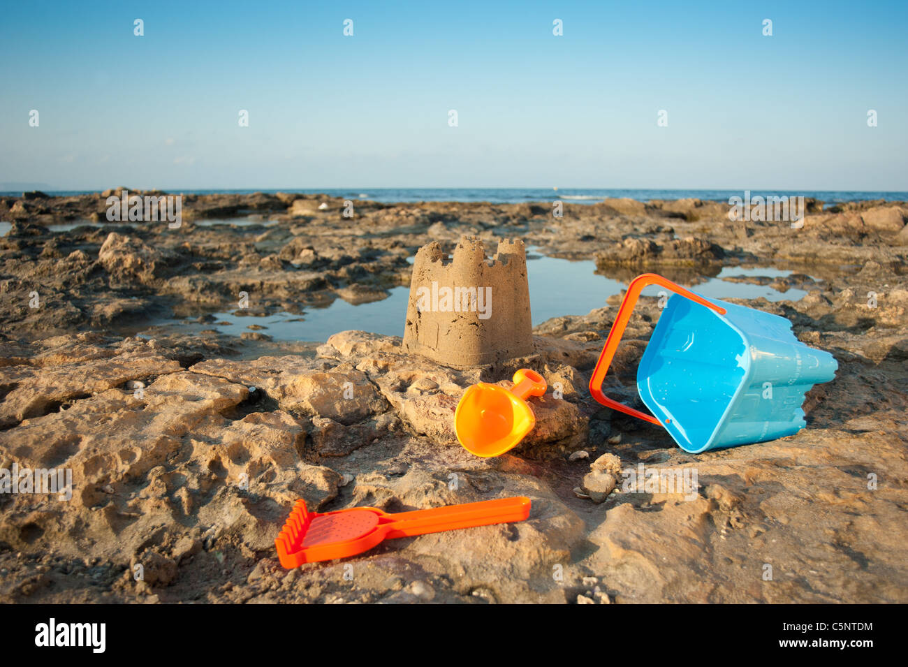 A sand castle and toy tools in scenic setting Stock Photo - Alamy