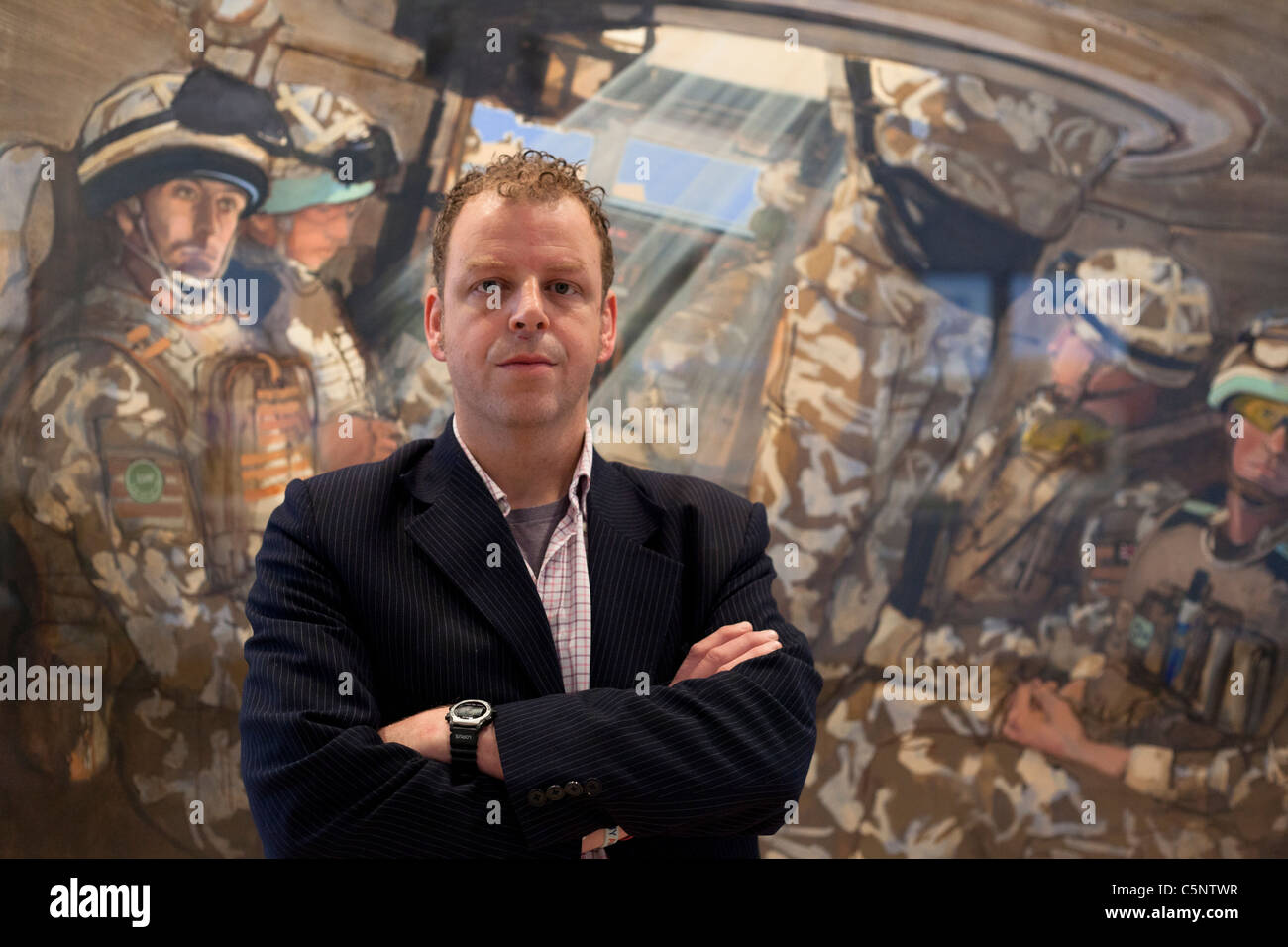 War artist Jules George stands in front of one of his paintings ...