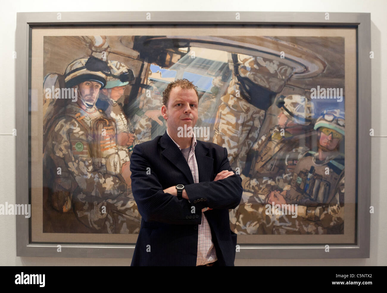 War artist Jules George stands in front of one of his paintings ...
