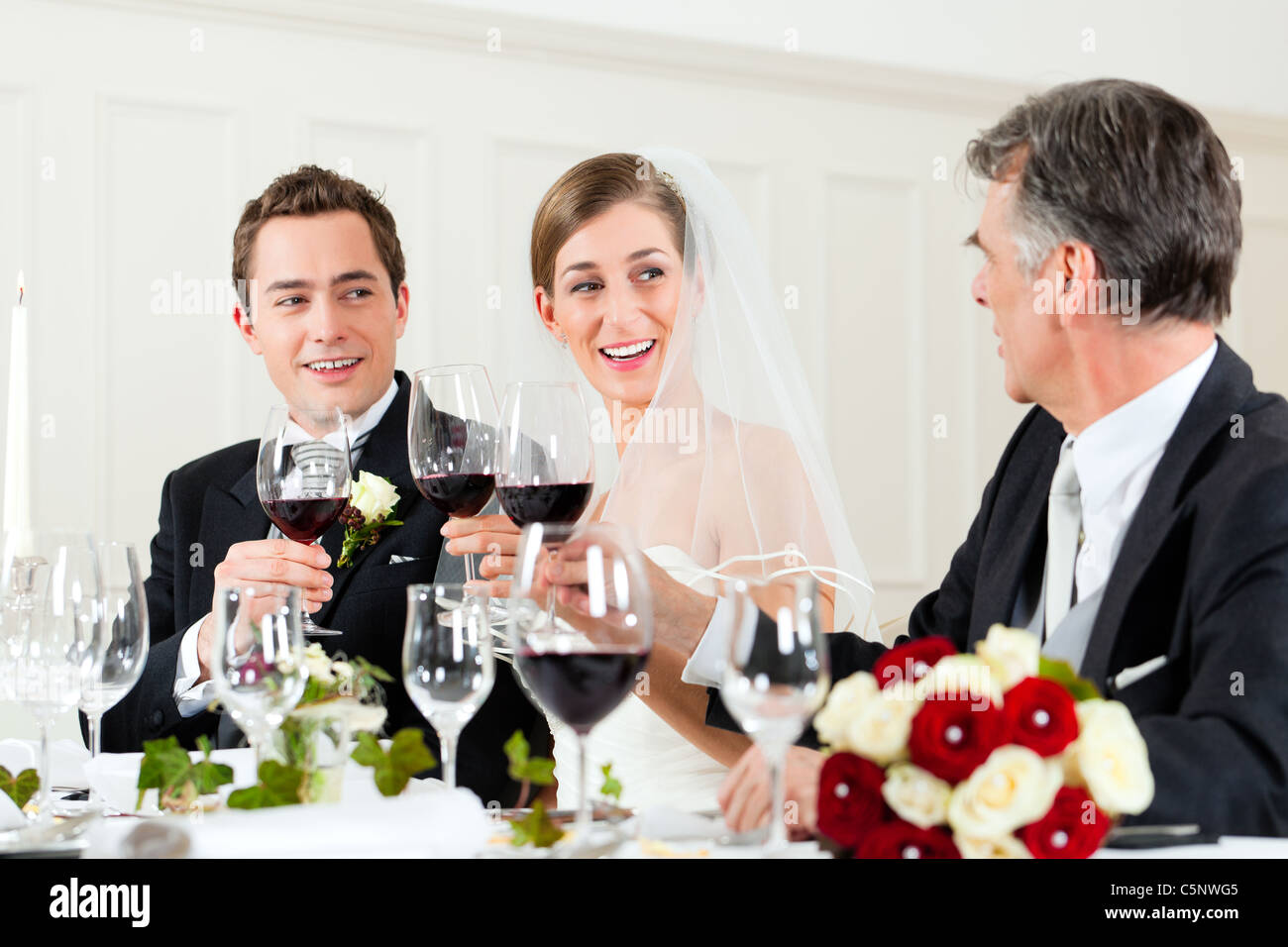 Wedding party at dinner - Bridal couple with father of bride Stock ...