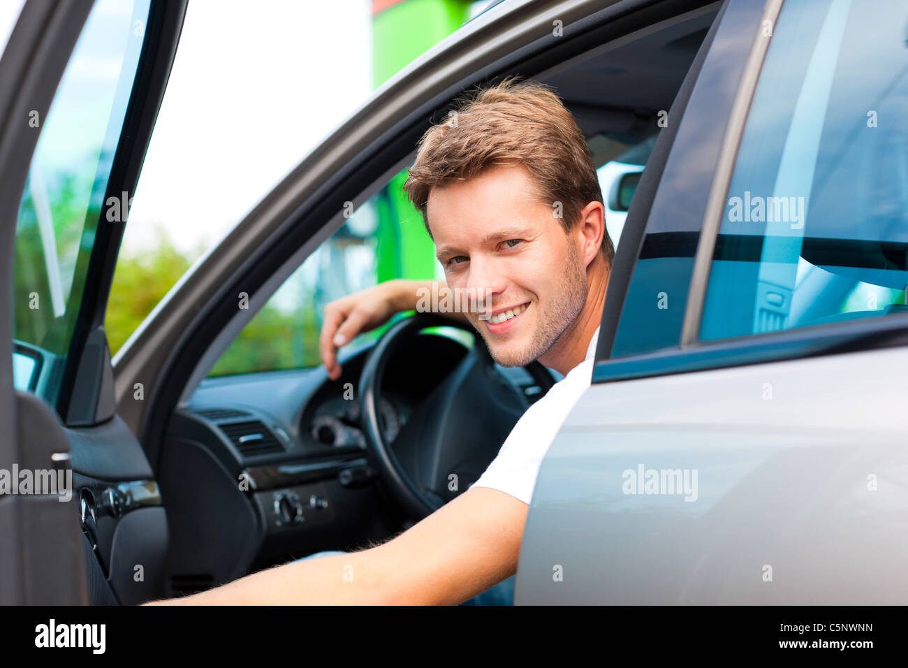 Man in his car stops at petrol station Stock Photo - Alamy