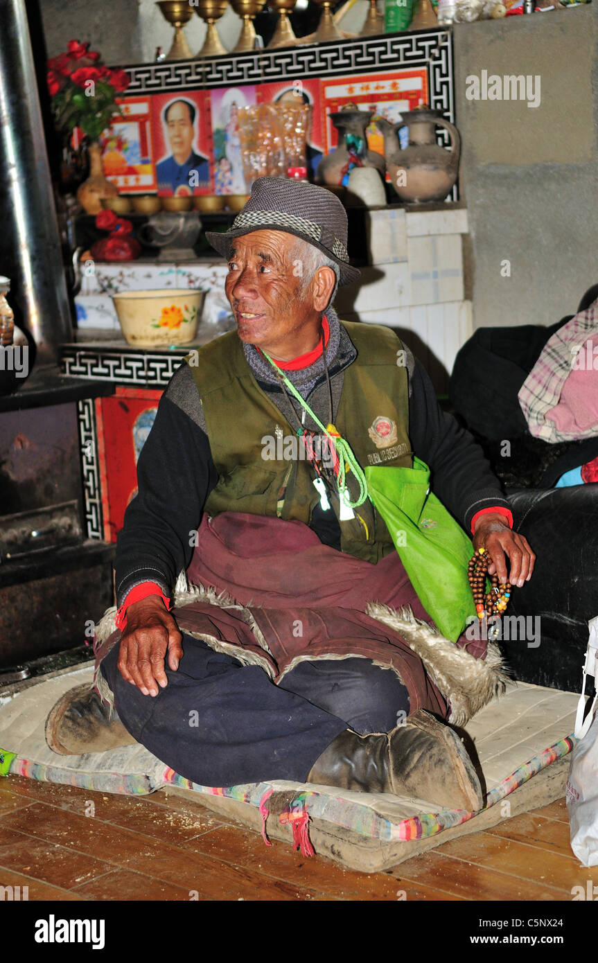 An old Tibetan man sitting in his house. Daocheng Yading, Sichuan ...
