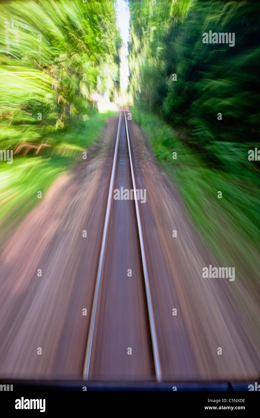 View of narrow gauge railroad track from rear window of train riding ...