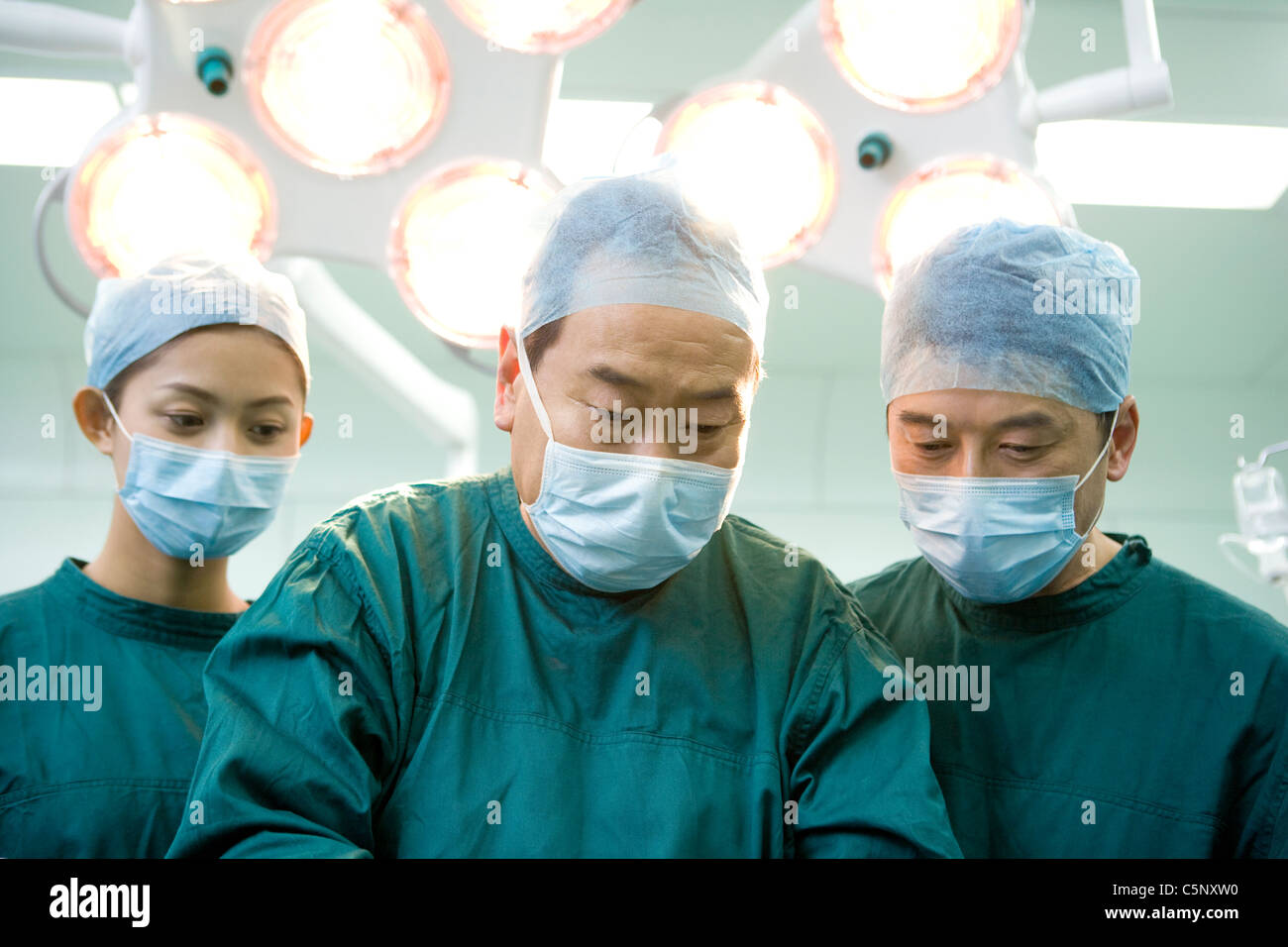Three surgeons focused on an operation Stock Photo - Alamy