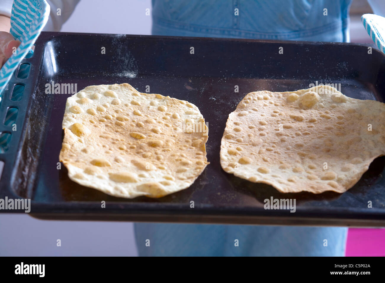 Matzah: : Woman holding a baking sheet with baked bread Stock Photo - Alamy