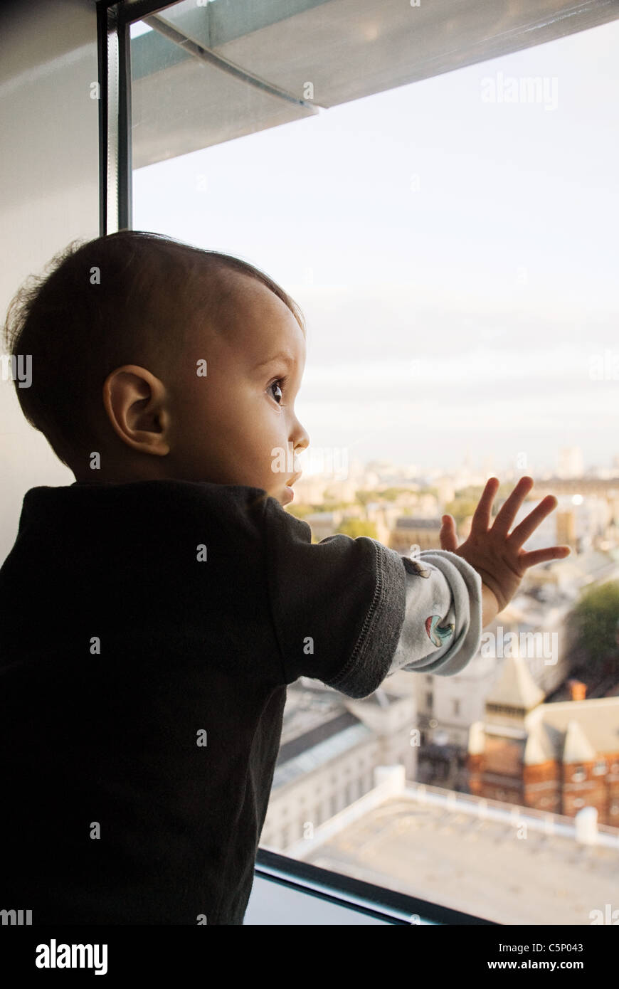 Baby boy touching window Stock Photo - Alamy