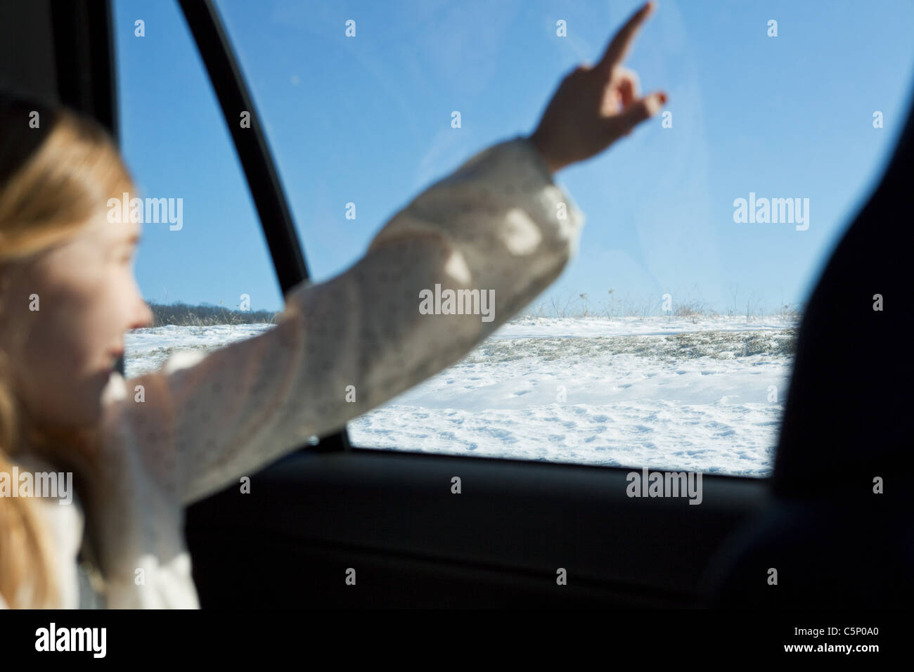 Young girl pointing through car window Stock Photo - Alamy